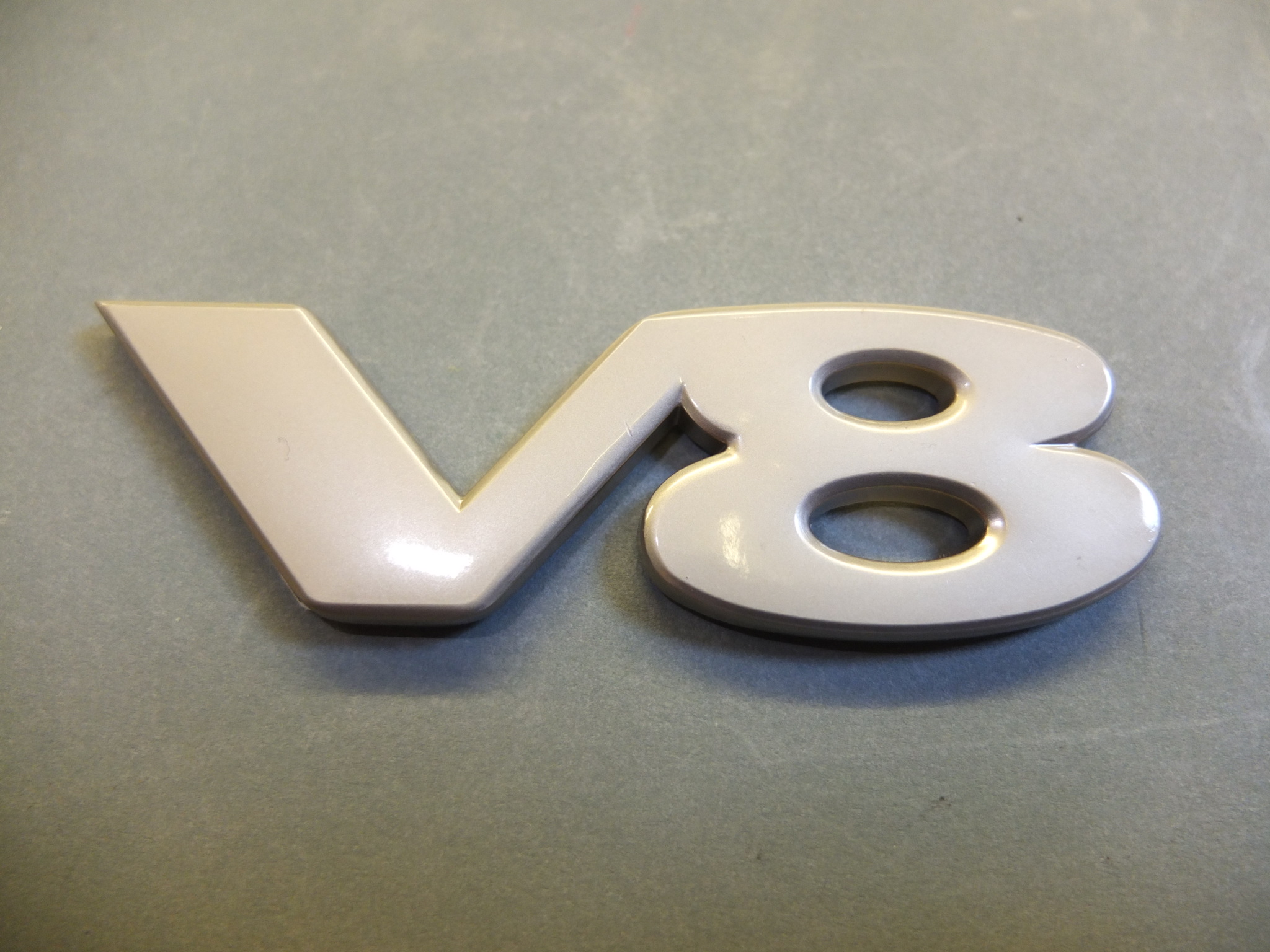 V8 Badge with self adhesive backing made from polished alloy.